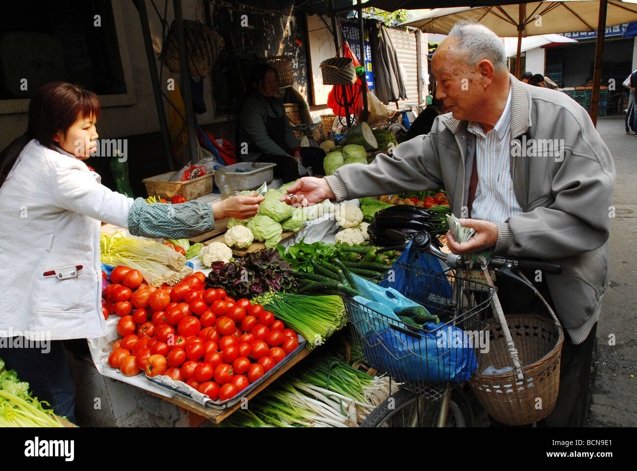 Elderly Chinese man buying vegetable from local farmers market, Chengdu ...
