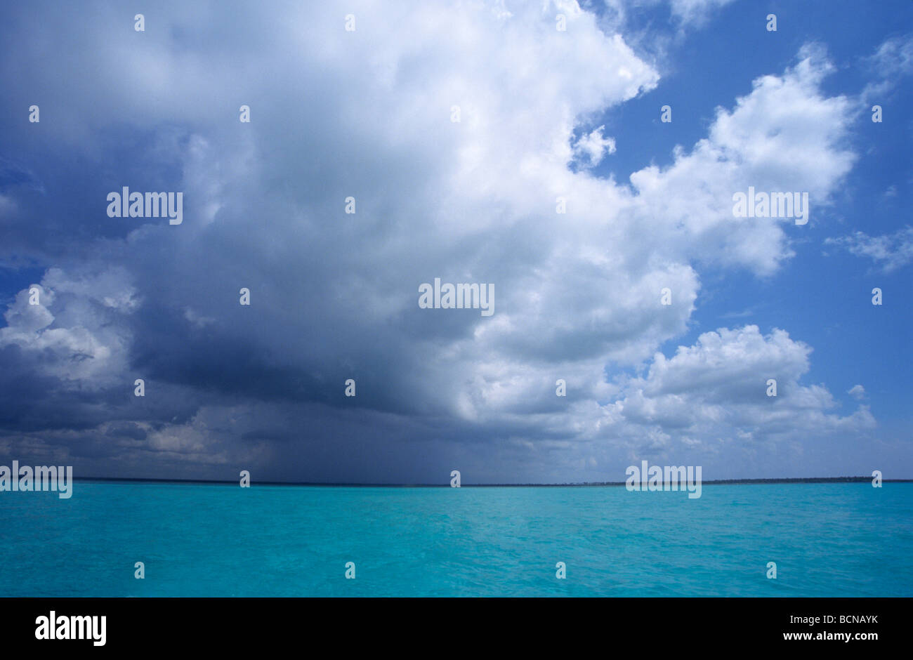 Rainfall from huge thunderstorm cloud falling in the blue lagoon water ...