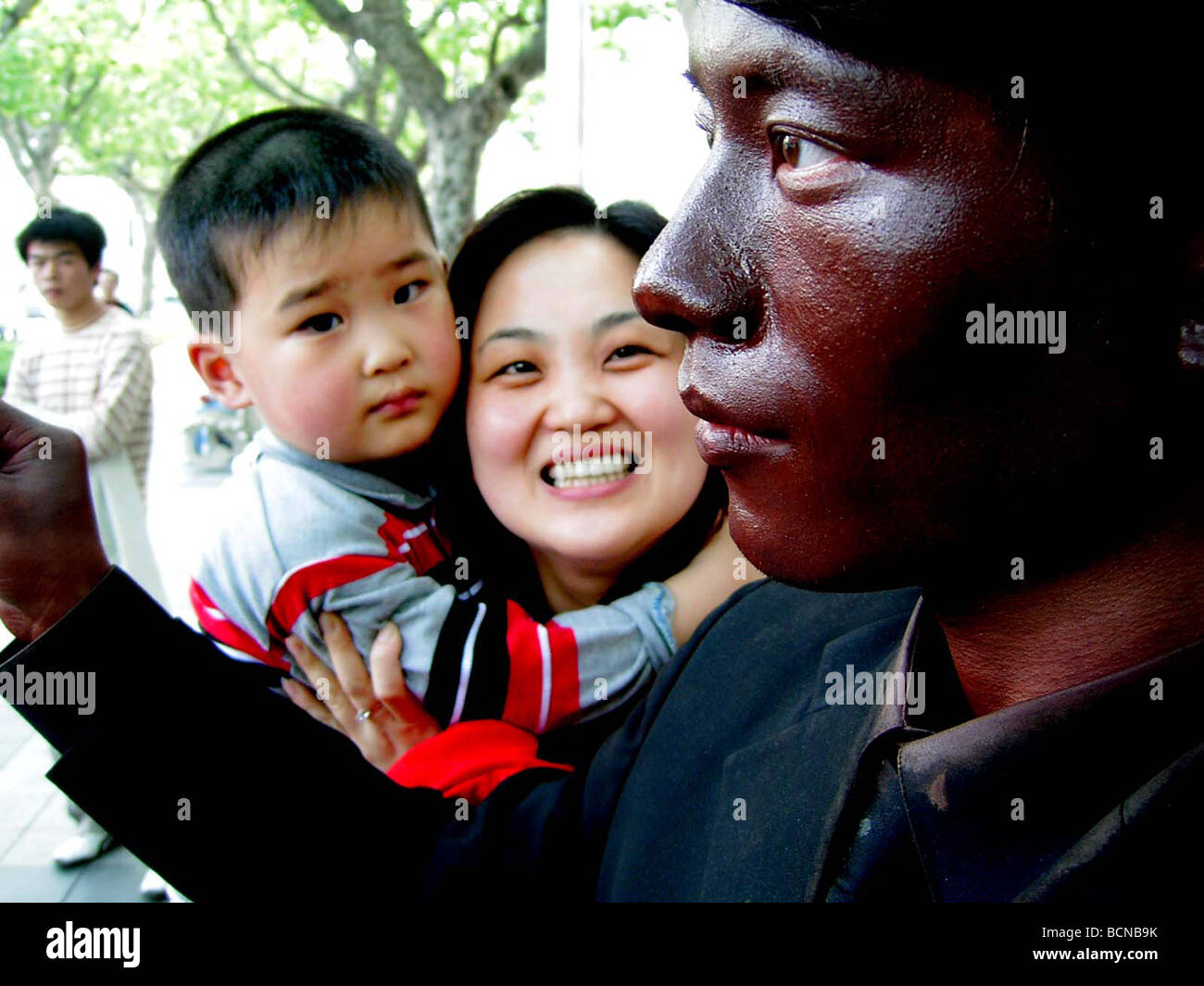 Mother and son looking at a Mime artist, Shanghai, China Stock Photo ...