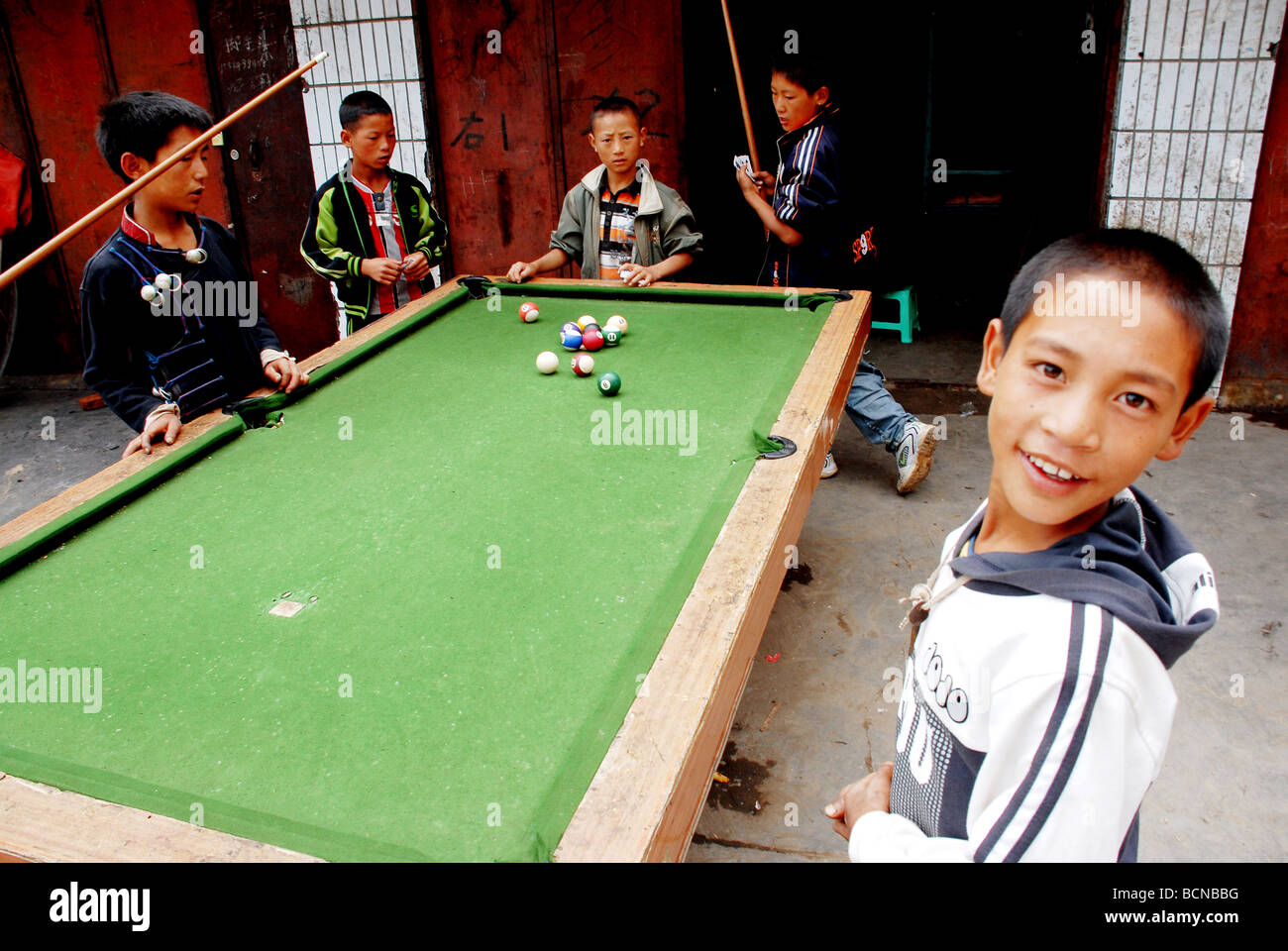 Yi Minority boys playing pool on the sidewalk, Liangshan Yi Autonomous ...