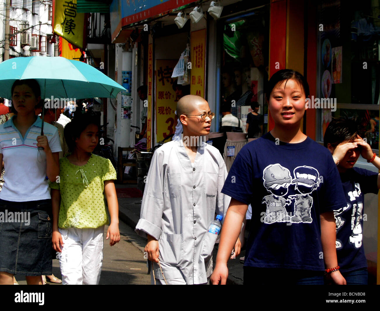 A Buddhist nun taking a walk on busy commercial street, Shanghai, China ...