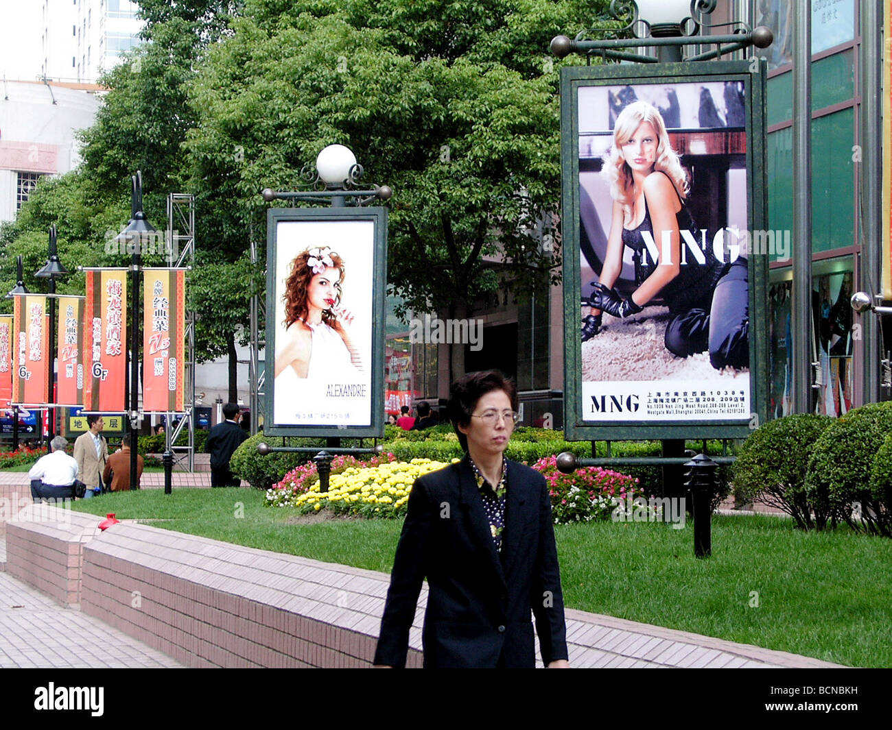 Woman walking pass outdoor advertisement of international fashion brand ...