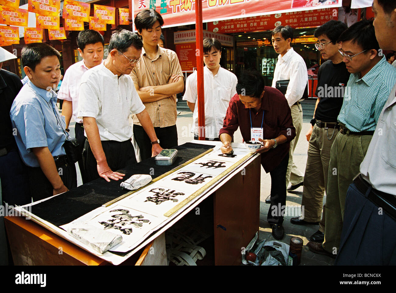 People watching artist writing calligarphy using his hand, Shanghai ...