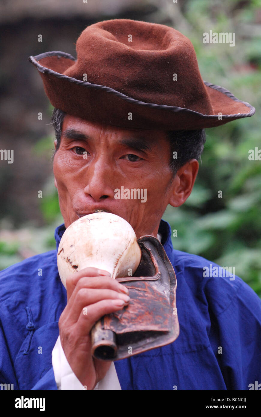 Ersu Tibetan man playing Tibetan Conch Shell Trumpet during Huanshan ...