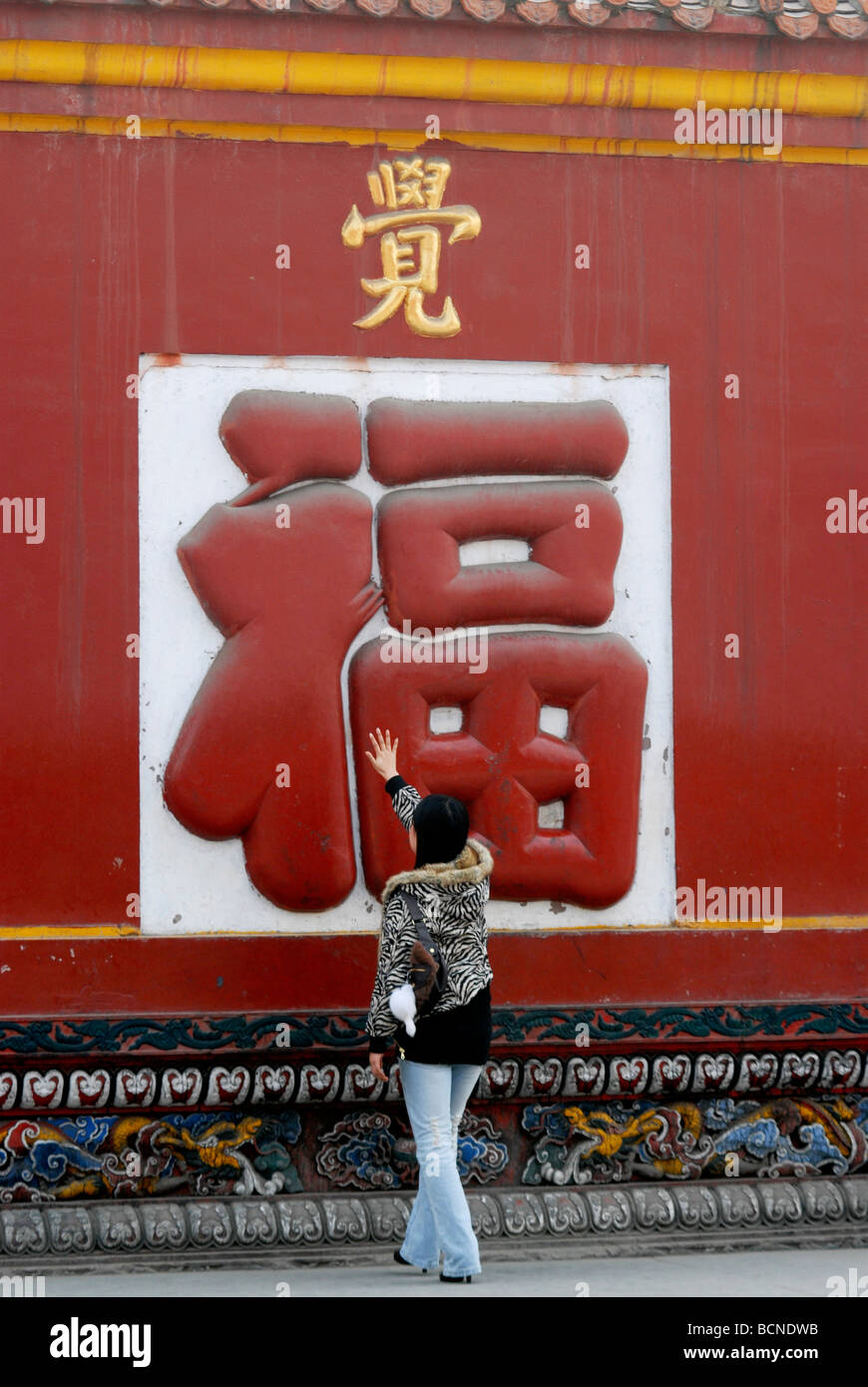 Chinese young woman touch the giant "Fu" character for blessing in ...