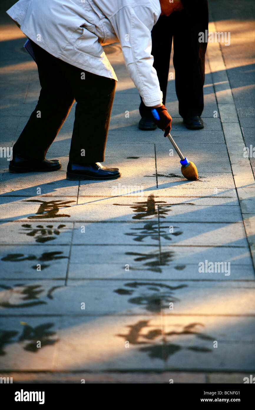 Chinese man practicing calligraphy using brush and water, Beihai Park ...