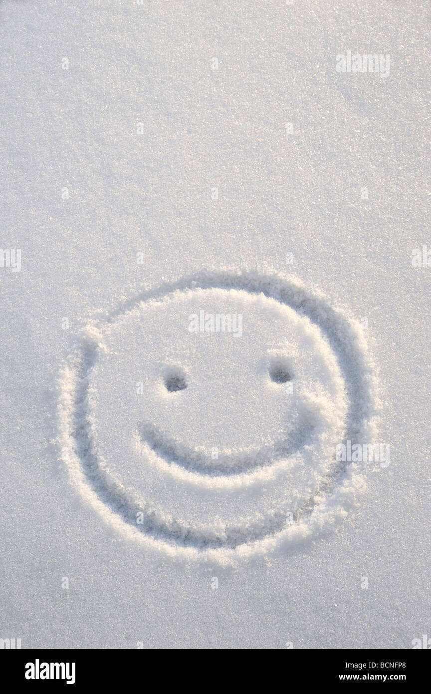 Smiley face drawn in snow in a sunny winter day Stock Photo - Alamy