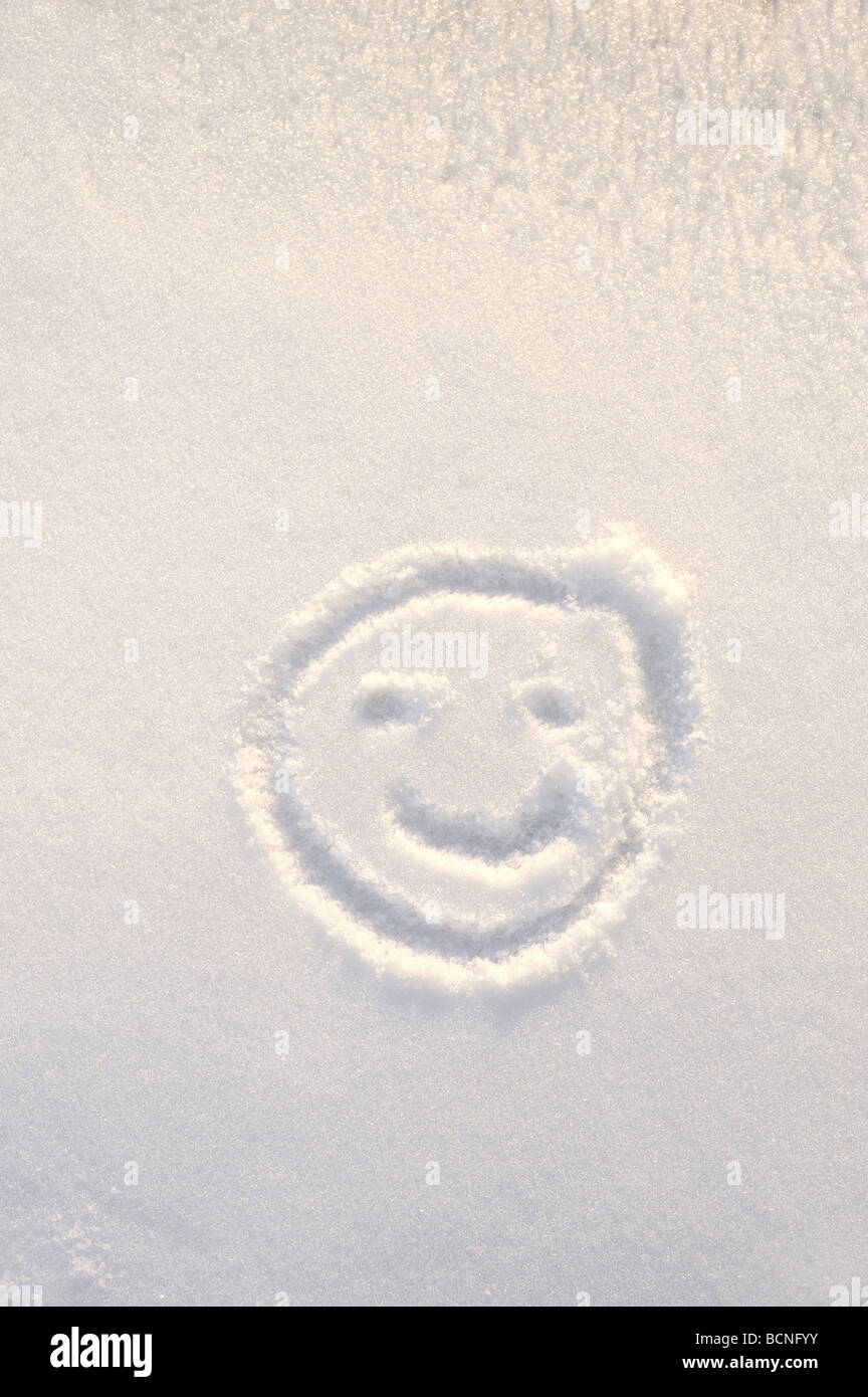 Smiley face drawn in snow in a sunny winter day Stock Photo - Alamy