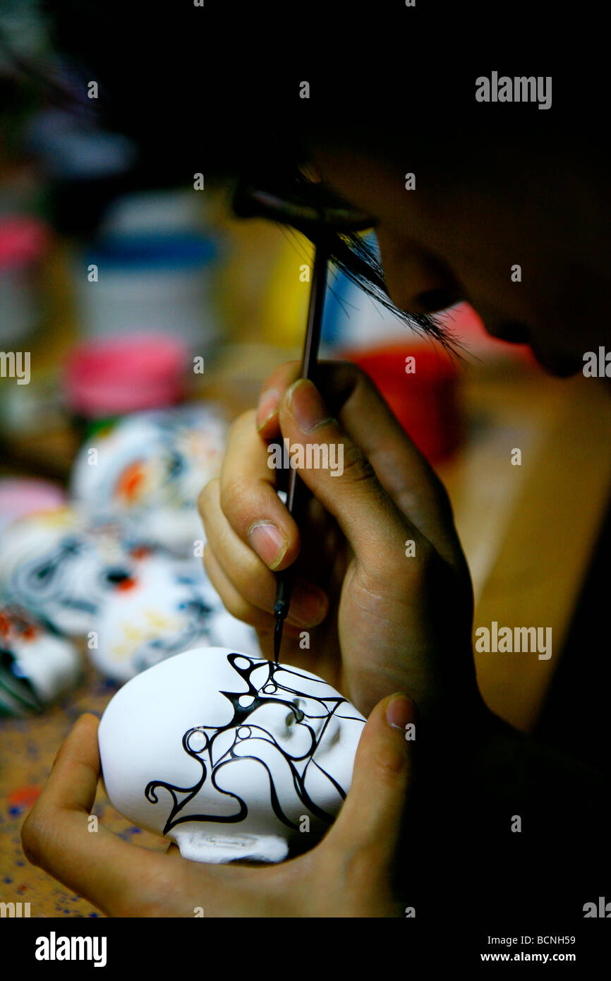 Young craftsman drawing the face of Peking opera facial design, Beijing ...