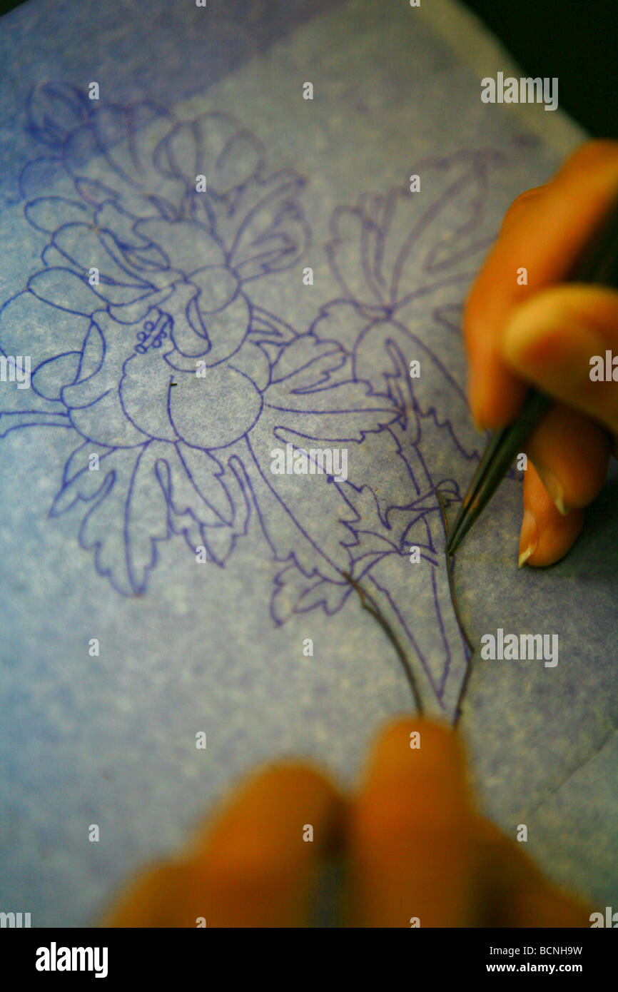 Worker bending silver wired according to pattern during filigree ...