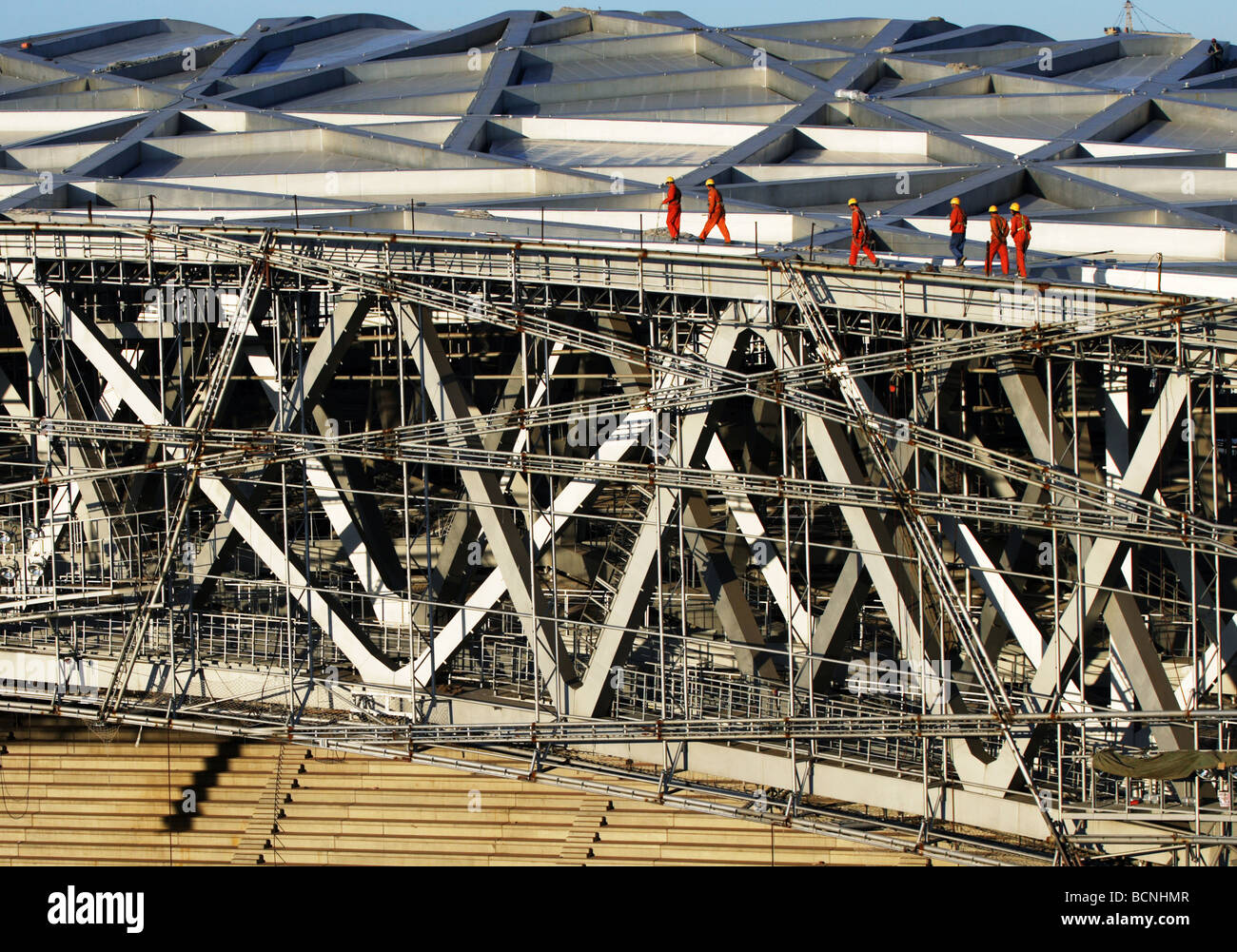 Construction workers on the massive steel roof of Bird's Nest under ...