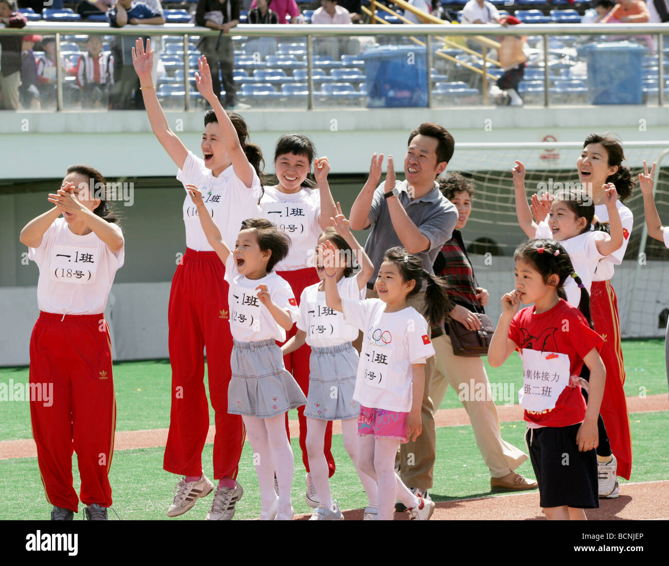 Elementry school kids and parents cheering at a sports competition ...