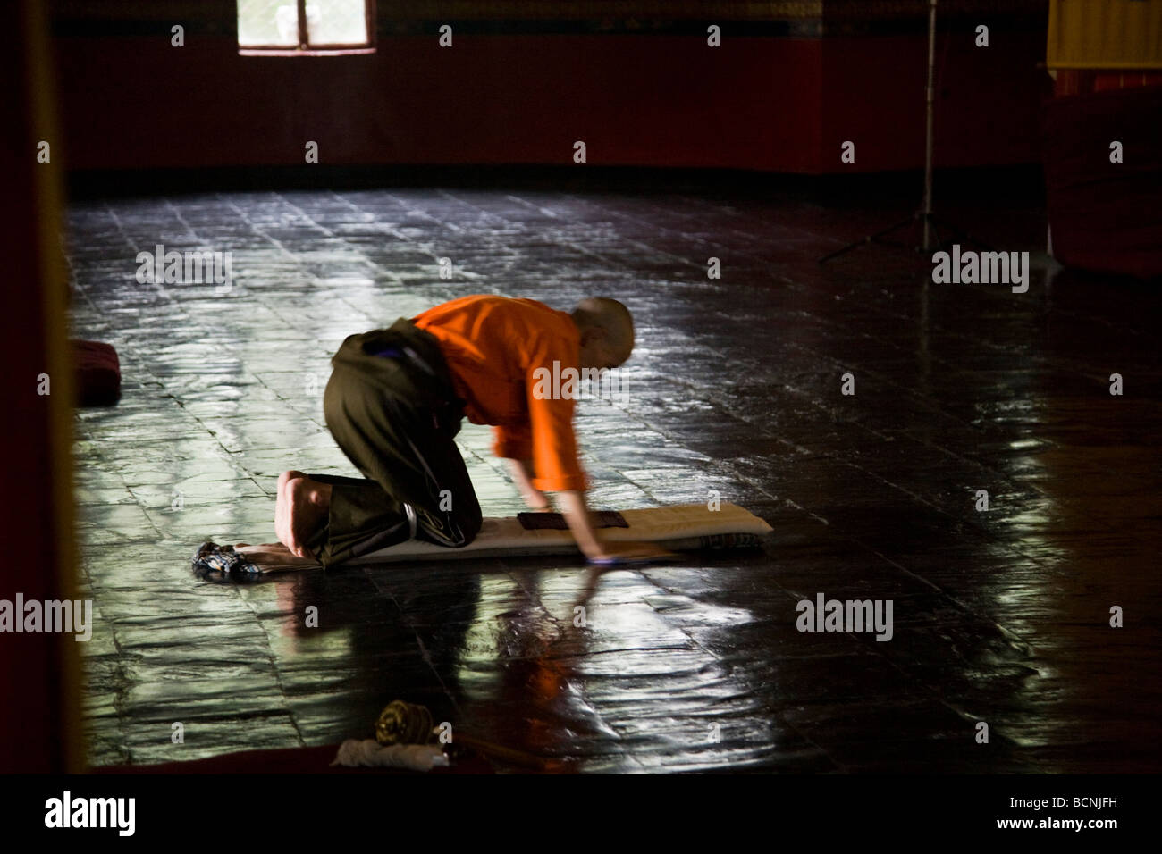 Buddhist prostrating in the main prayer room at the Norbulingka ...