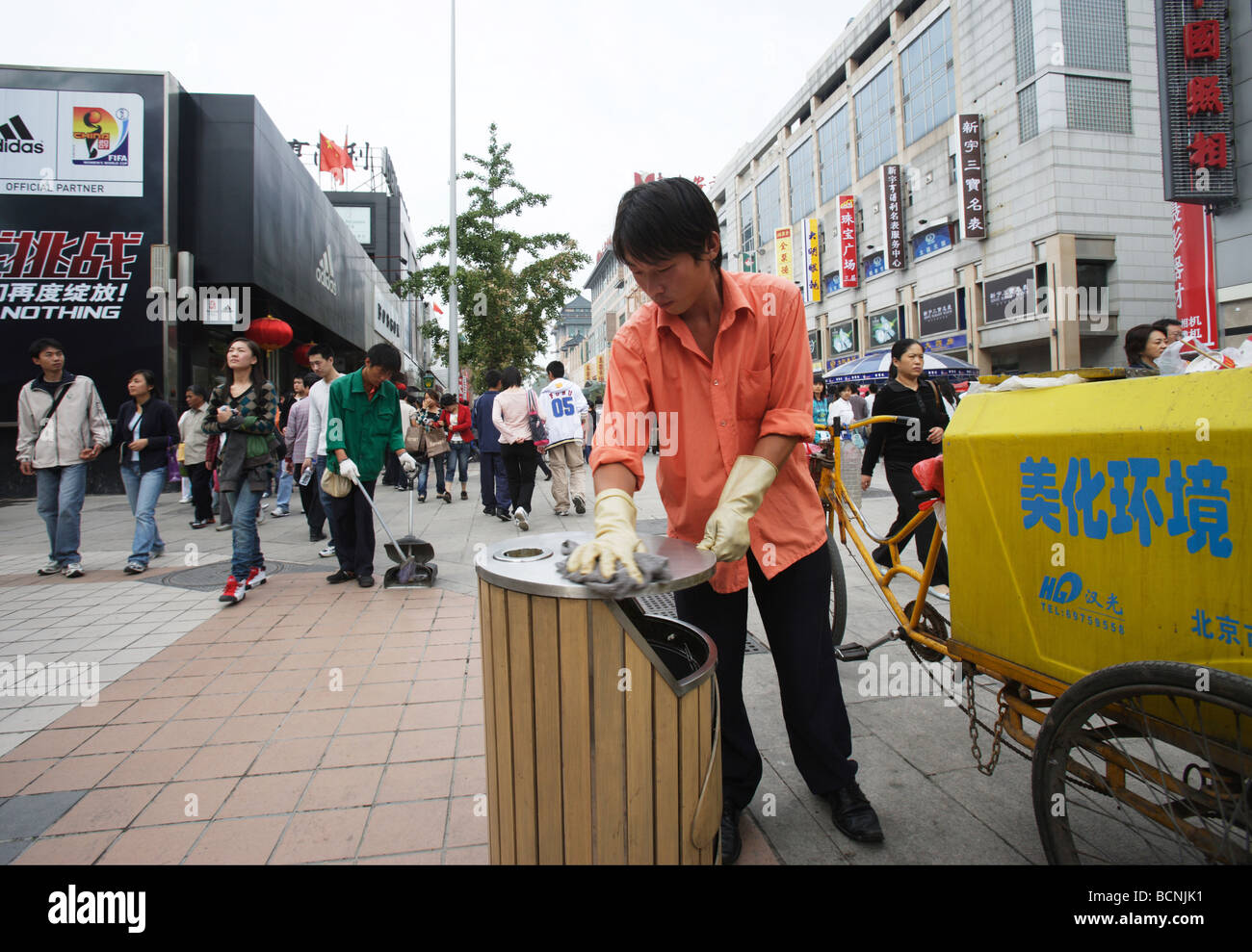Janitor cleaning trash bin in Wangfujing Street, Beijing, China Stock ...