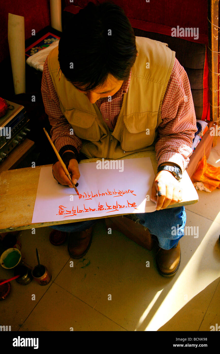 Tibetan man writing Tibetan language using red ink, Lhasa, Tibet ...