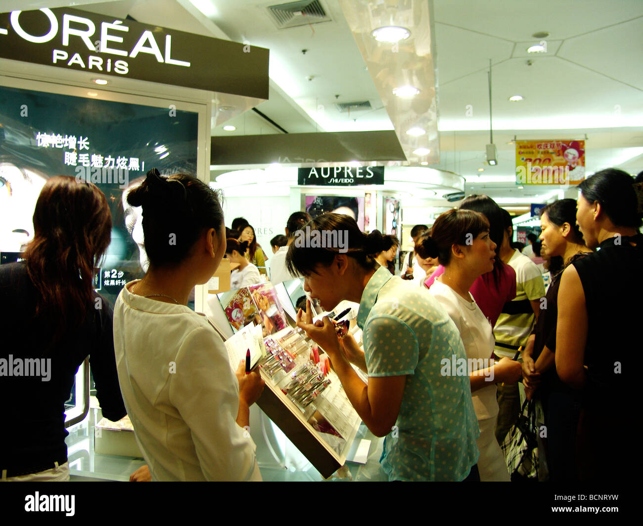 Young women try out make up products in cosmetic counter, Xidan ...