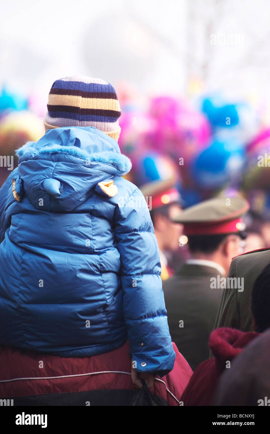 Boy sitting on father's shoulder watching performace, Gulou Street ...