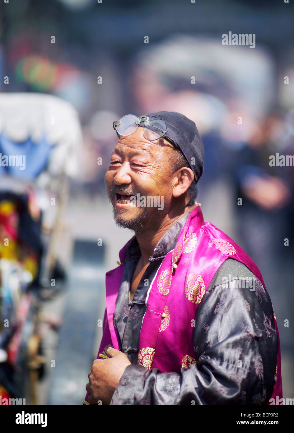 Smiling rickshaw driver in traditional Chinese costume waiting for ...