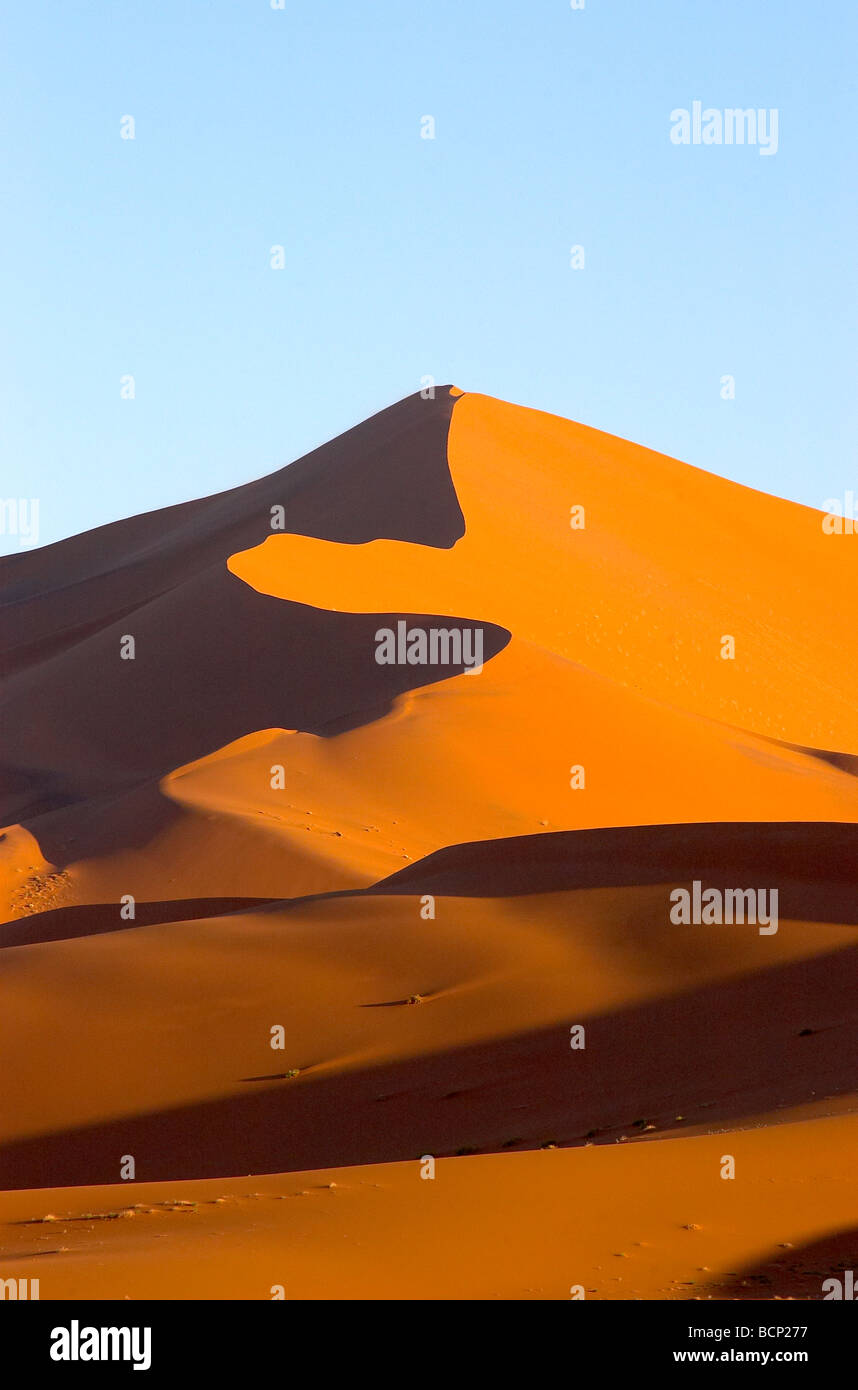 Namibian sand dunes. The Sossusvlei sand dunes push into the valley ...