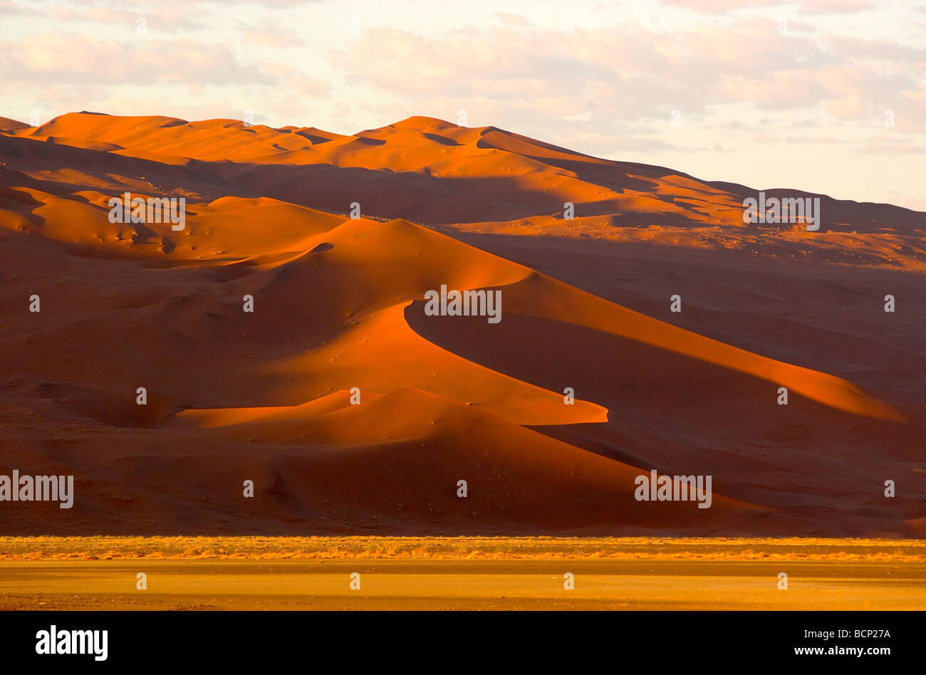 Namibian sand dunes. The Sossusvlei sand dunes push into the valley ...