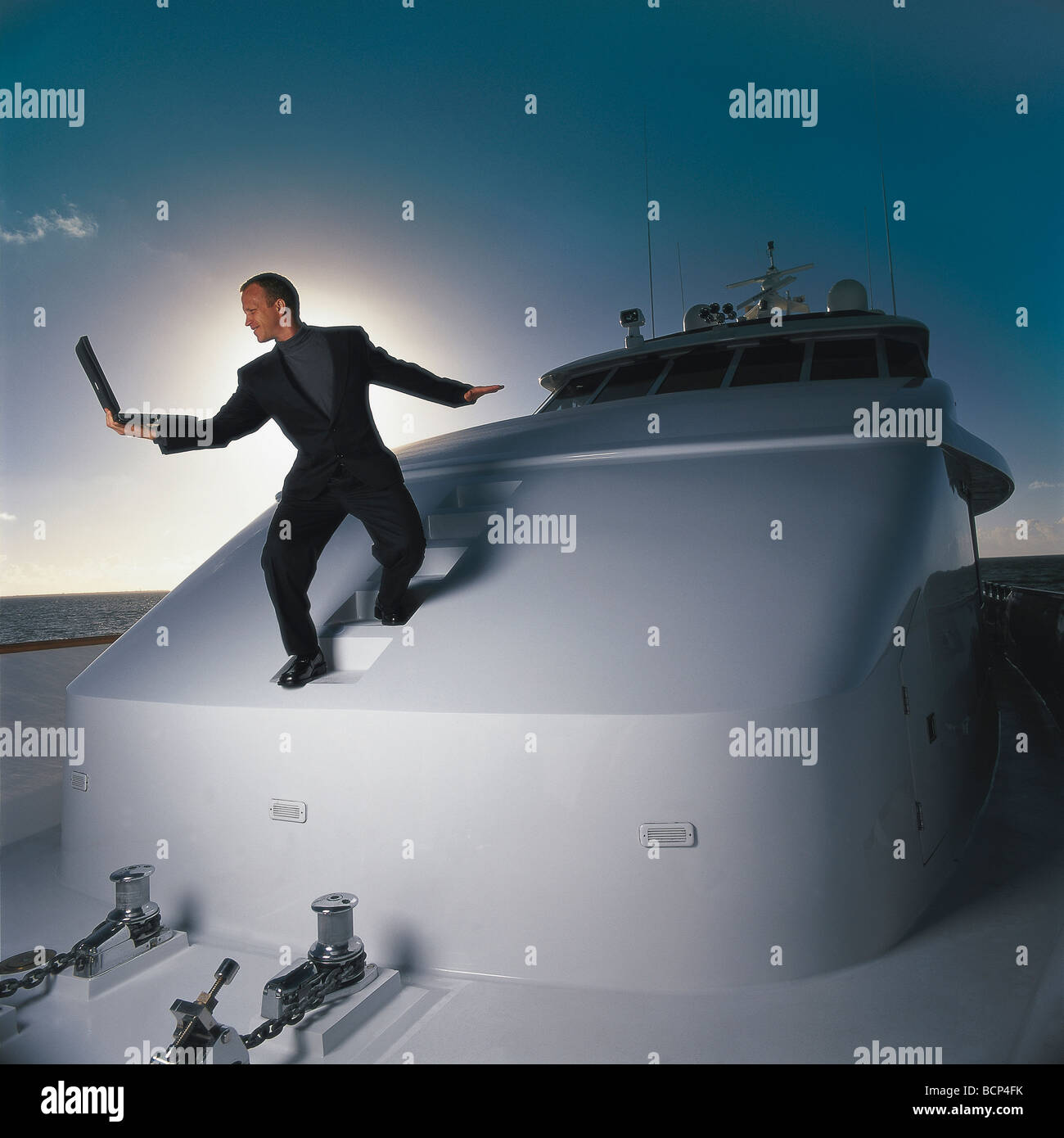 Man on super yacht holding computer Stock Photo - Alamy