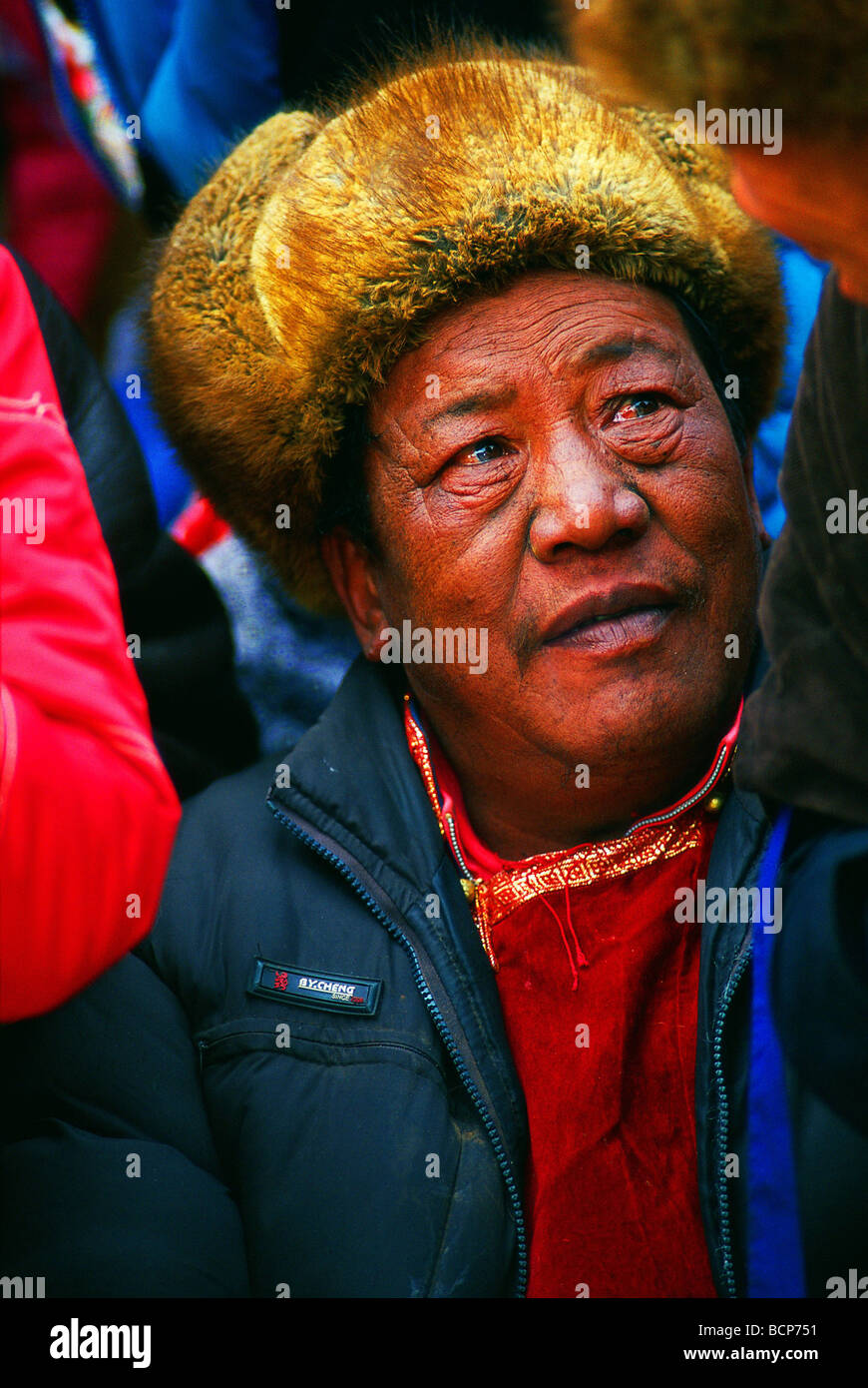 Tibetan man wearing traditional fur hat and modern down coat, Shangri ...