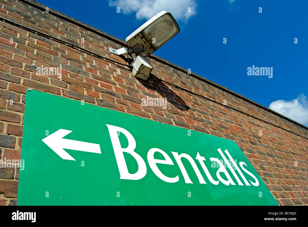 sign on a brick wall showing the way to bentalls, a department store ...