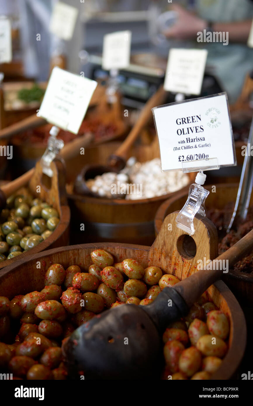 Green olives on display at a market stall in wooden barrels Stock Photo ...