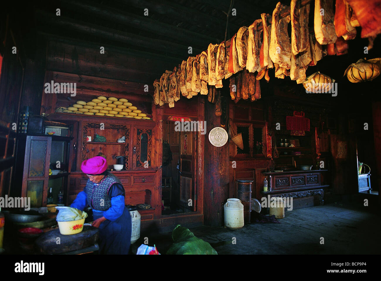 Tibetan woman working in the kitchen of a traditional Tibetan home with ...