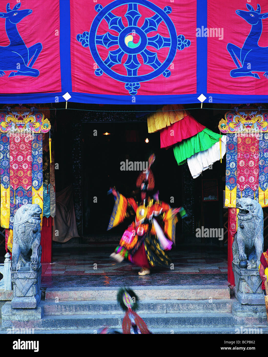 Lama in elaborate ceremonial robe and mask performing religious Cham ...