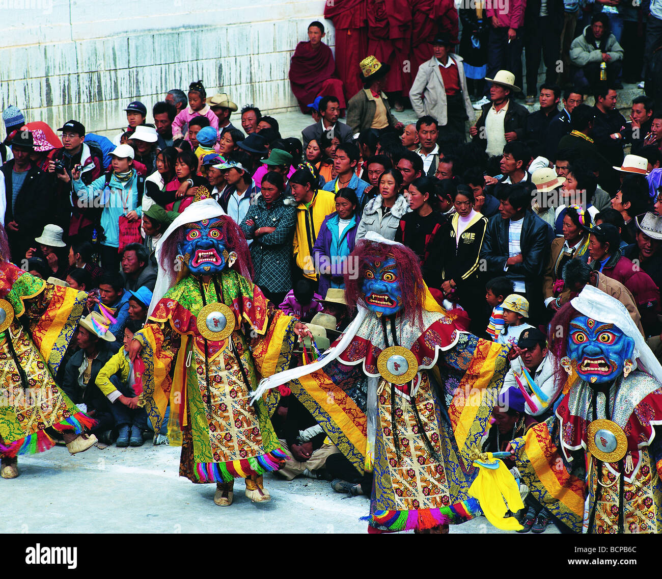 Lamas in elaborate ceremonial robe and mask performing religious Cham ...