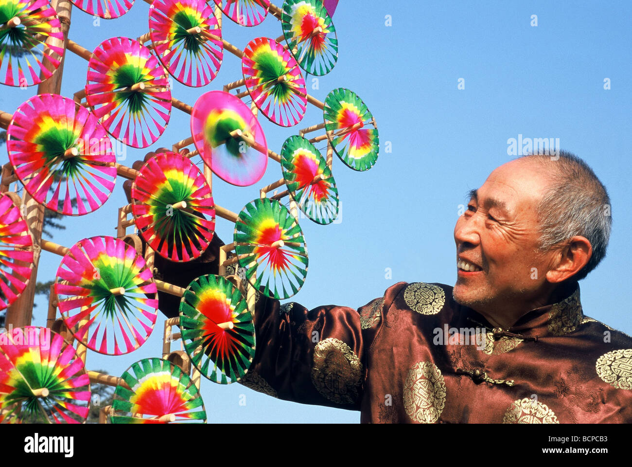 Elderly Chinese man wearing traditional clothing playing Beijing ...