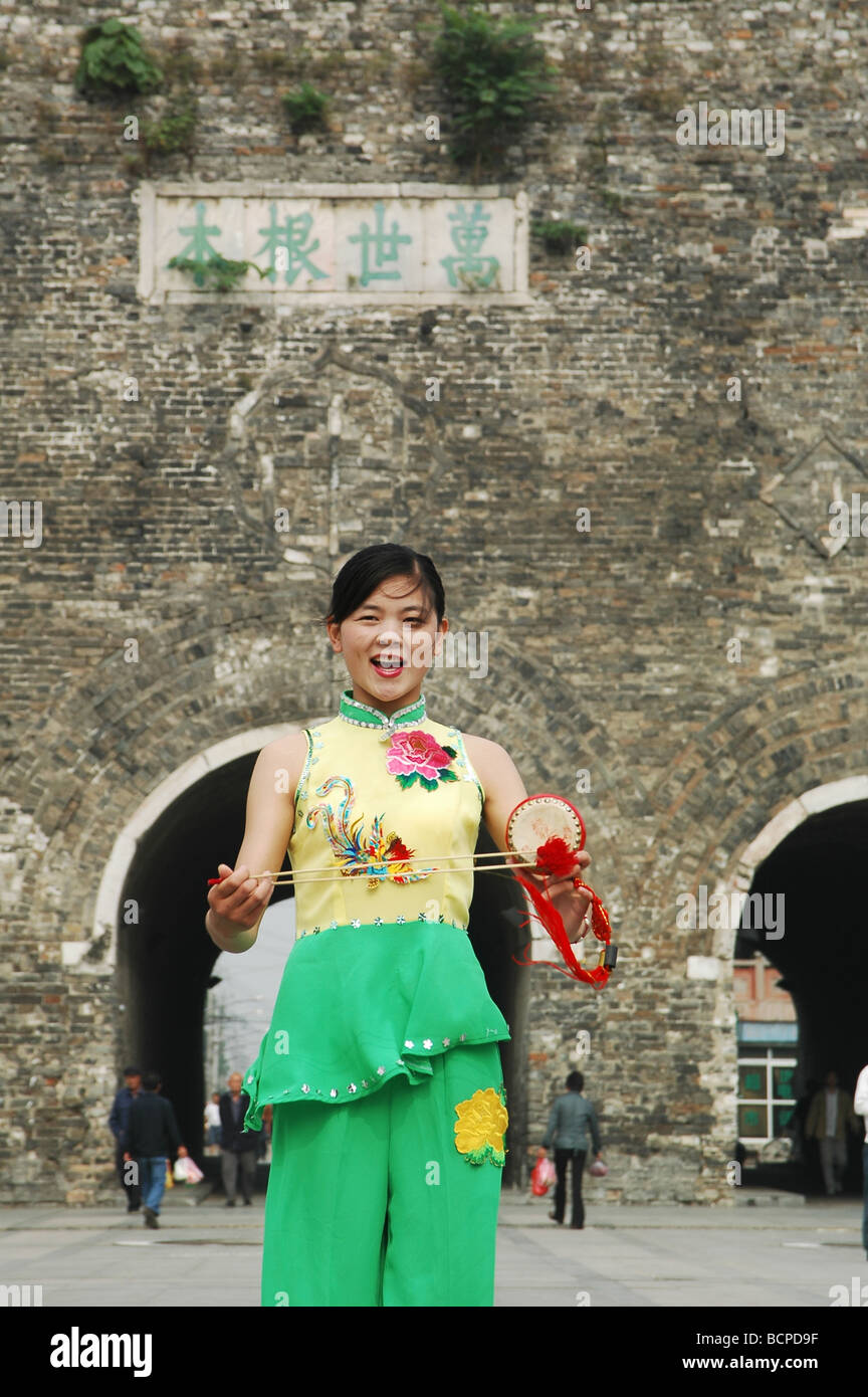 Young female Flower Drum Opera actress performing in front of ancient ...