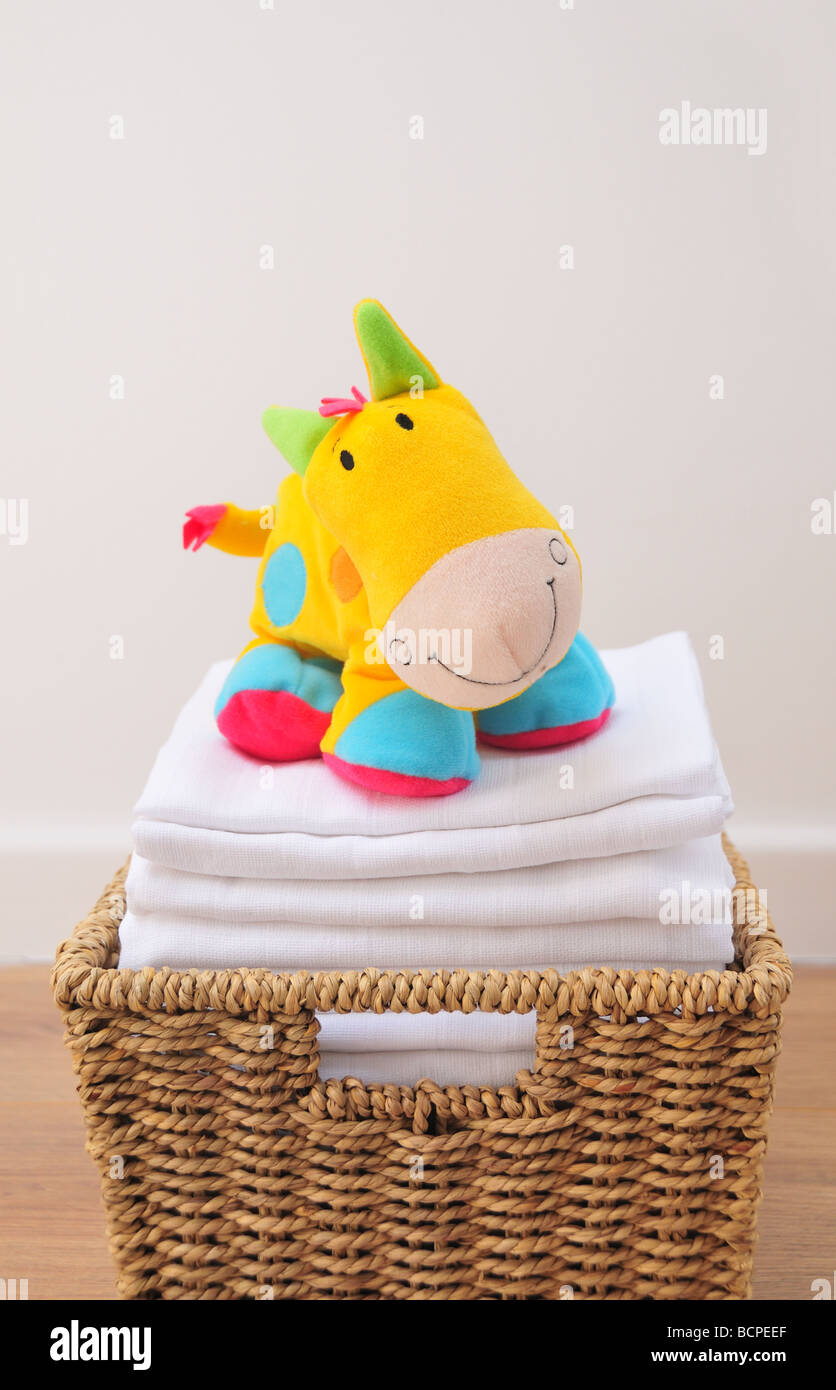 A cute colourful baby toy on a top of folded muslim squares placed in a ...