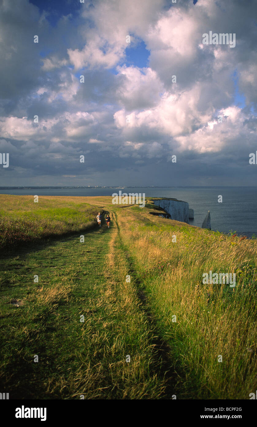 Two joggers running along the South West Coastal Path past Old Harry ...