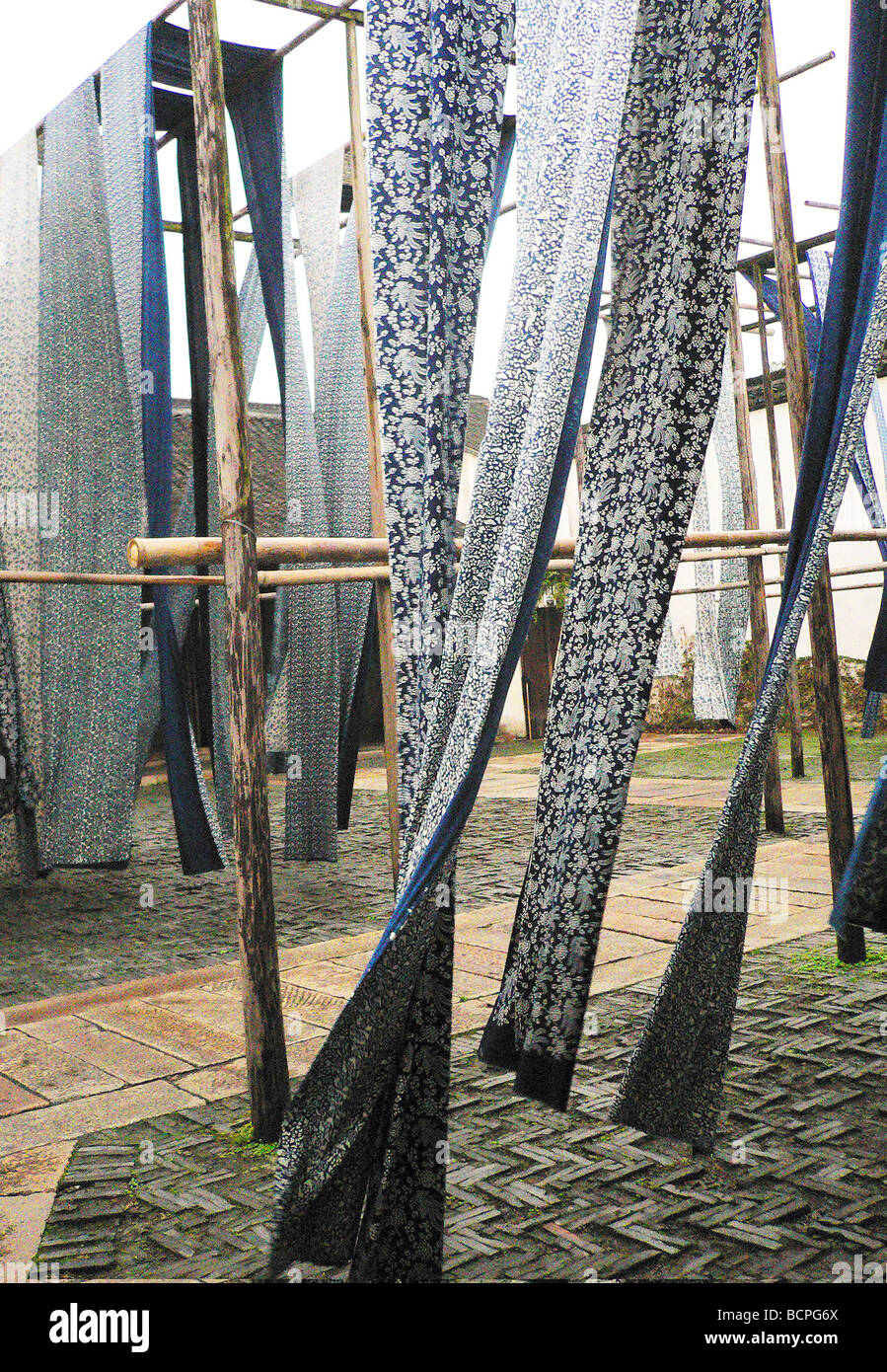 Blue and white patterned cloth drying in the courtyard of dyeing shop ...