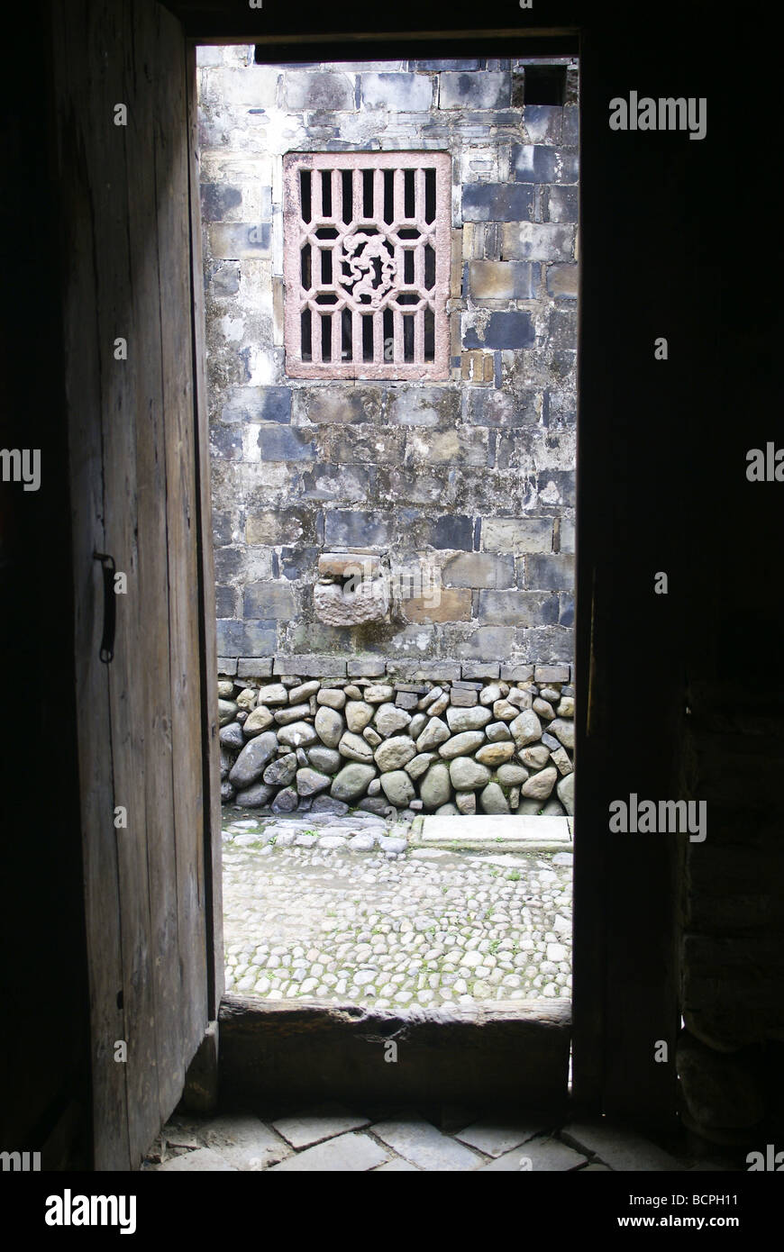 Stone carved lattice window on the stone wall of a traditional ...
