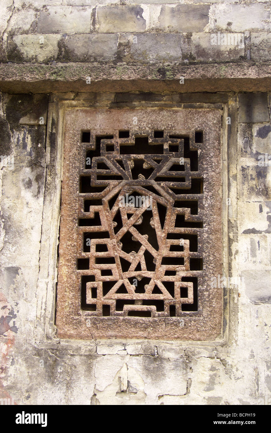 Stone carved lattice window on the stone wall of a traditional ...