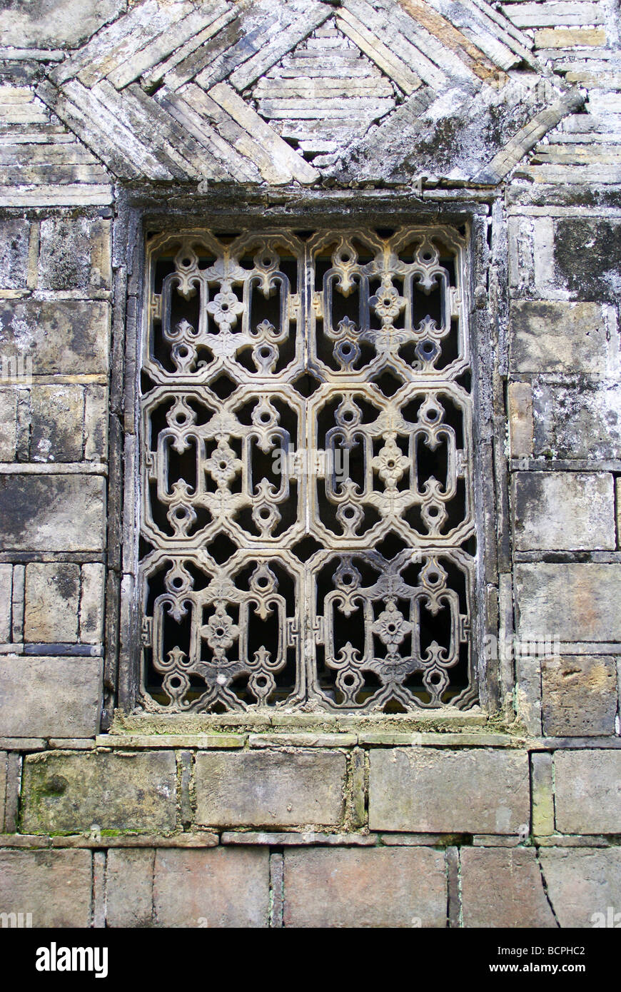Stone carved lattice window on the wall of a traditional residence ...