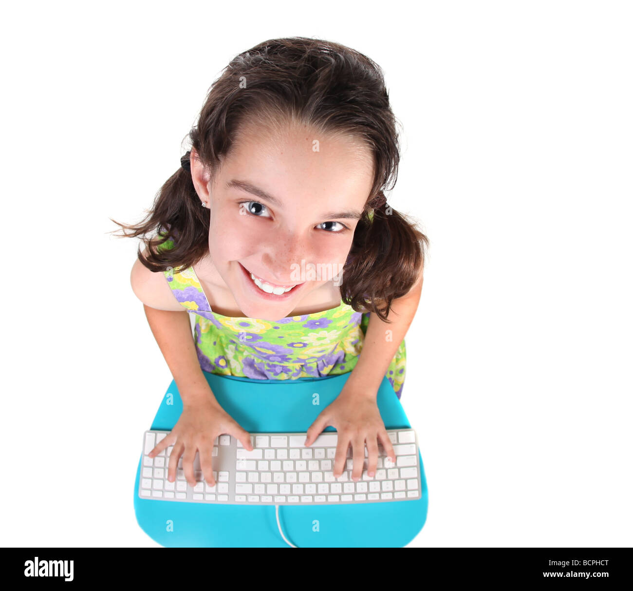 Cute Little Girl Typing on a Computer Keyboard Looking Up on White ...