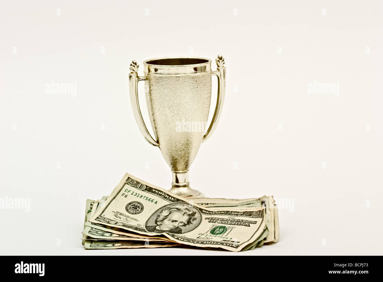 Cash at the foot of a trophy cup Stock Photo - Alamy
