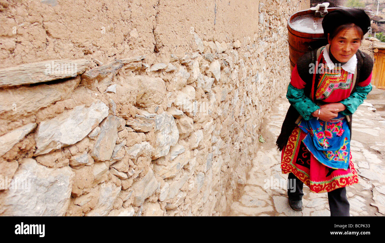 Qiang minority woman in traditional clothing carrying water, Luobozhai ...
