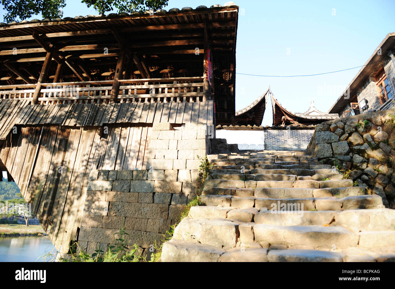 Stone stairs lead to the 700 years old wooden covered bridge in Pingnan ...