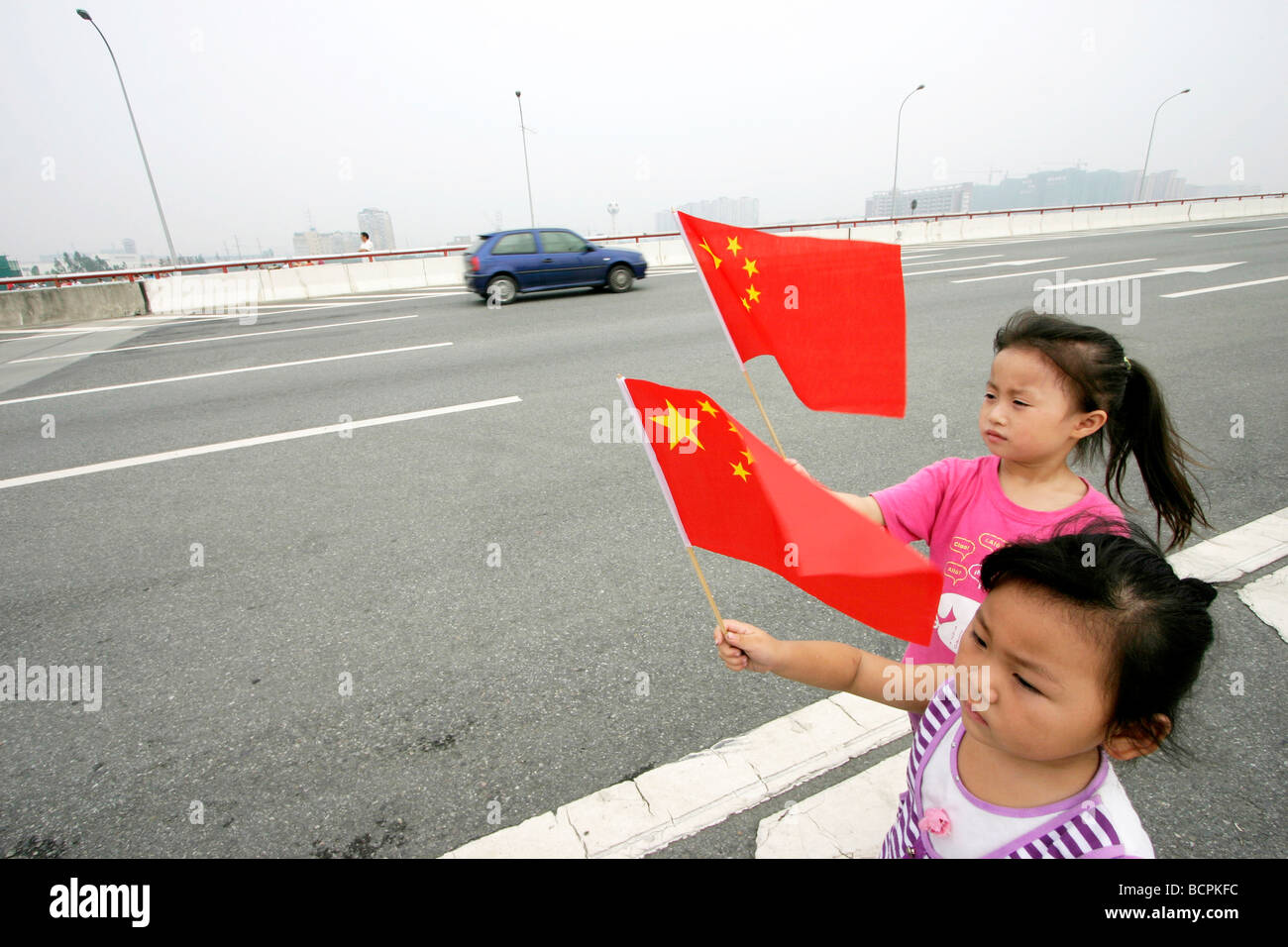 Young Chinese girls waving Chinese flag welcoming 2008 Beijing Olympic ...