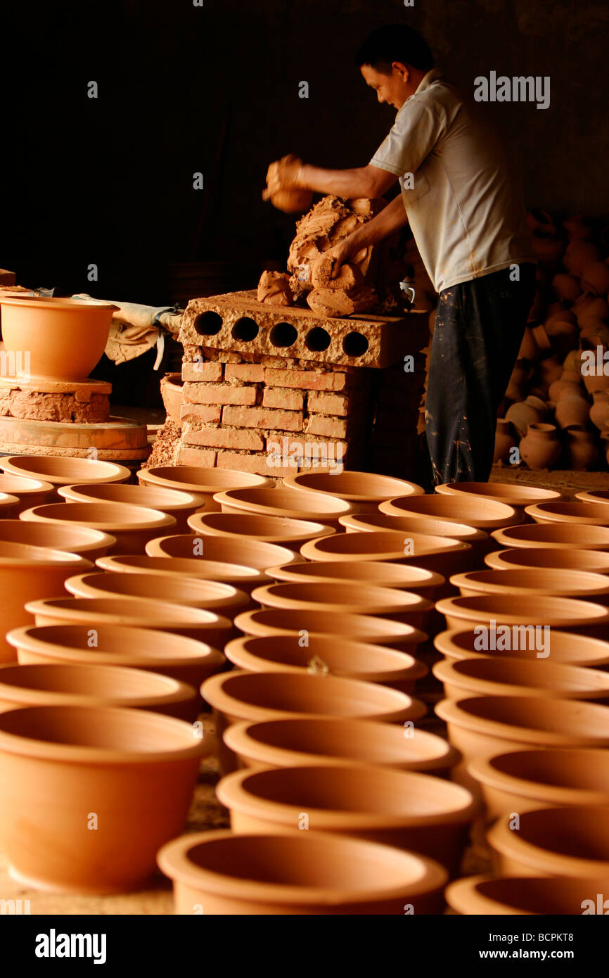 Skilled craftsman preparing clay dough in local clay kiln, Shuangliu ...