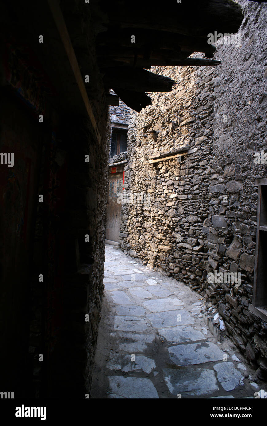 Narrow dark alley between stone houses built by Qing minority, Taopin ...