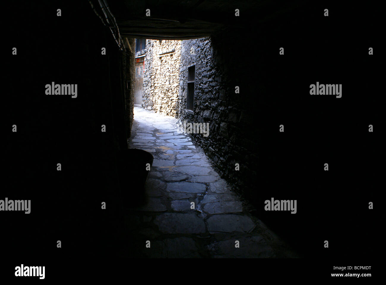 Narrow dark alley between stone houses built by Qing minority, Taopin ...