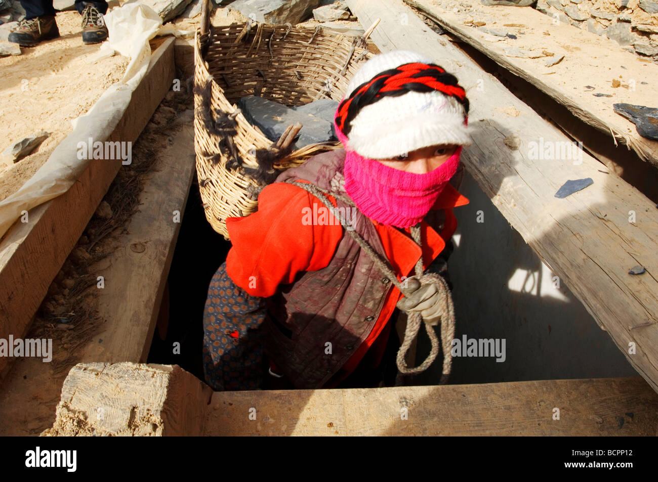 Tibetan woman carrying stones in the construction site of a local ...