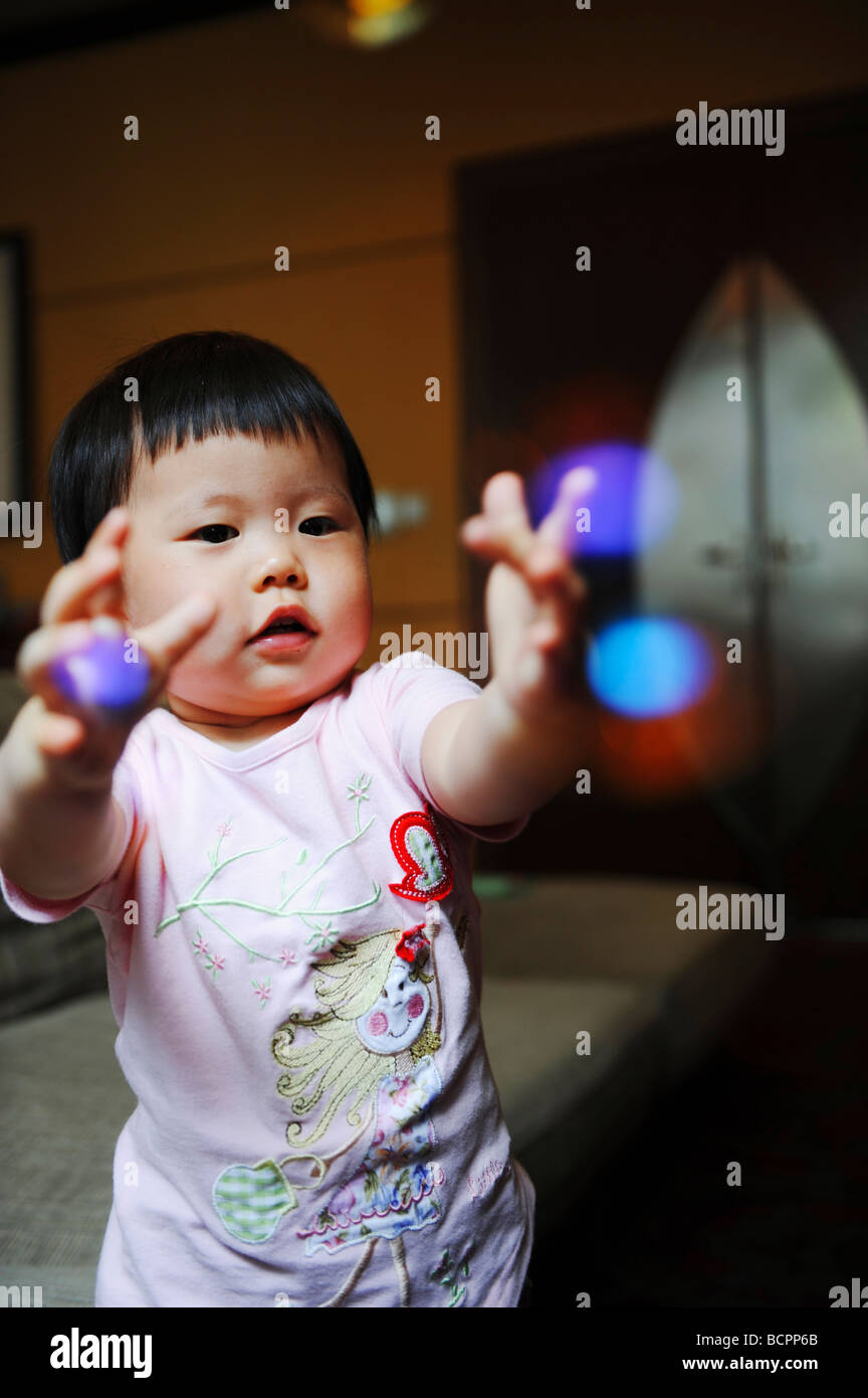Chinese baby girl stretching out her arms in living room, Chengdu ...