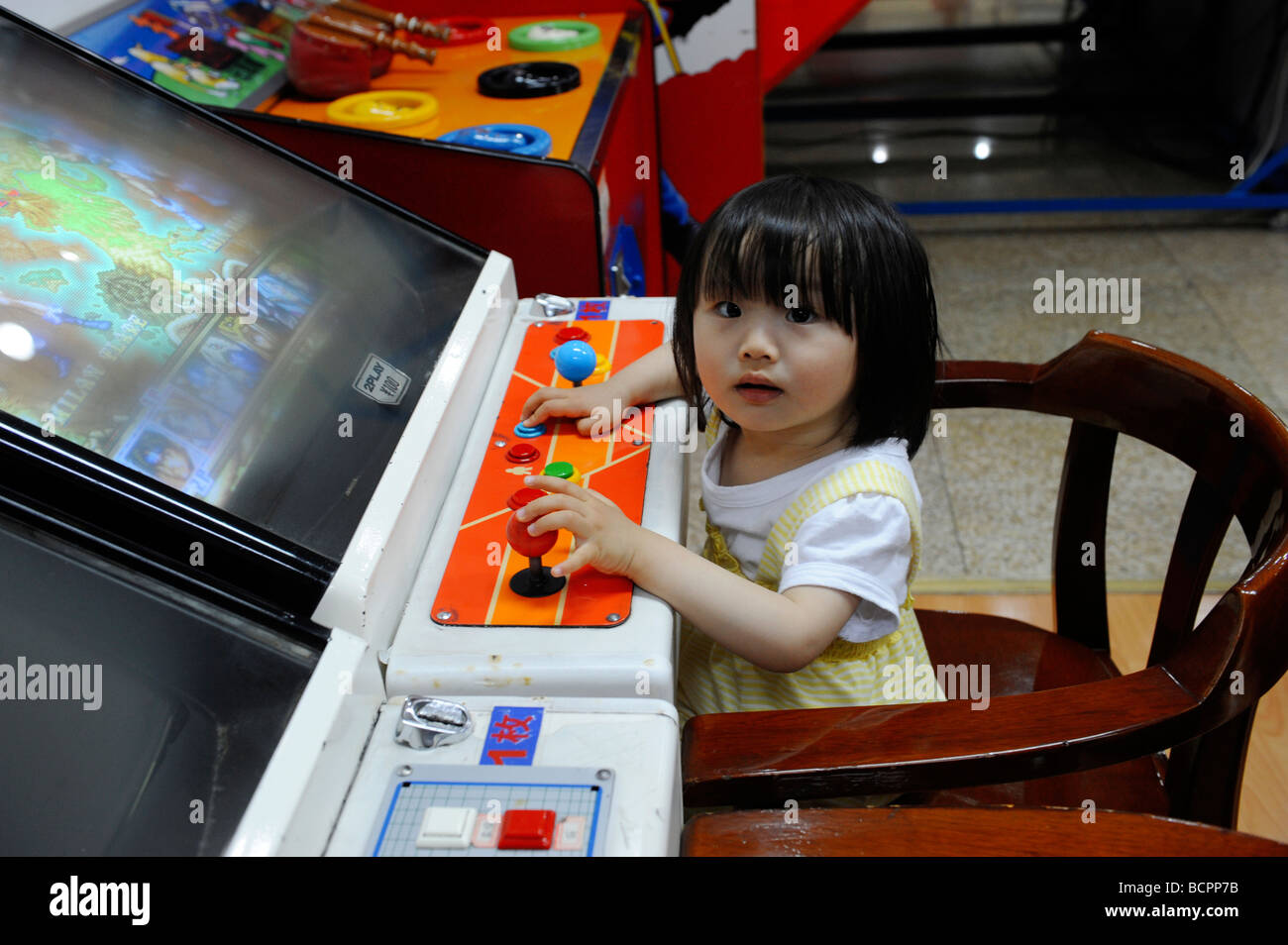 Young Chinese girl playing game in a local video arcade, Chengdu ...